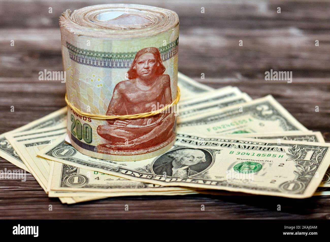 Egyptian money roll of 200 LE and pile of American money isolated on ...