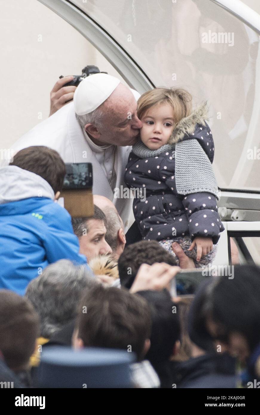 Pope Francis kisses a child as he arrives for a special audience, at ...