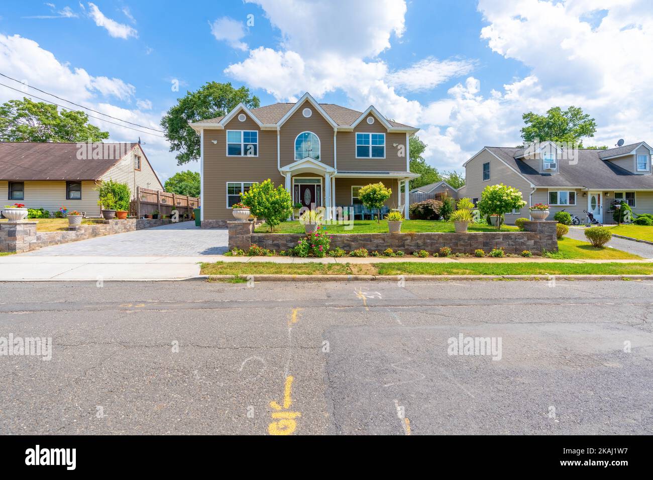 An exterior of beautiful big houses with backyards under the cloudy sky ...