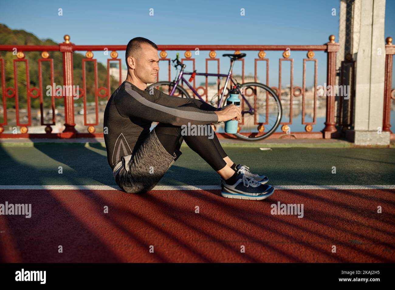 Tired man athlete sitting after morning sport activities Stock Photo ...