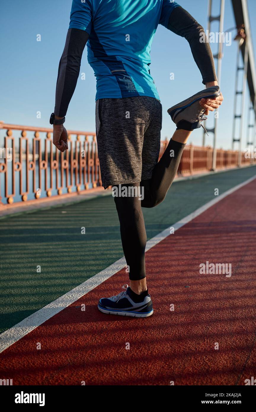 Adult Healthy Fitness Man Runner Stretching Legs Before Running Stock