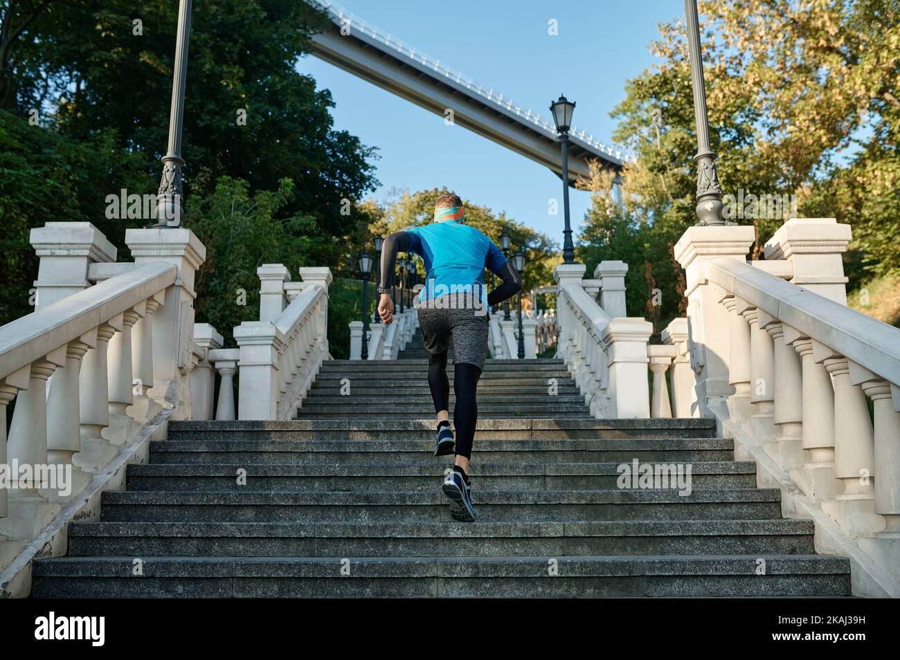 Back view of sportsman running upstairs over urban background Stock ...