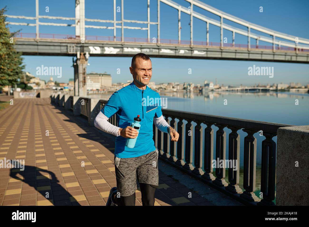 Attractive fit man running fast along the river Stock Photo - Alamy