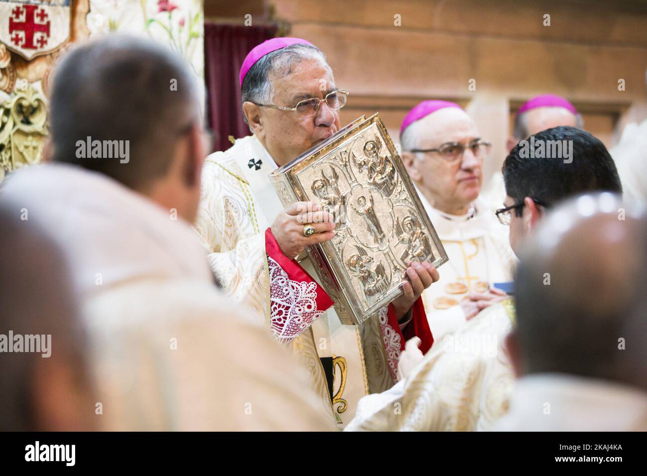 Latin Patriarch of Jerusalem Fouad Twal kisses the Book of the Gospels ...