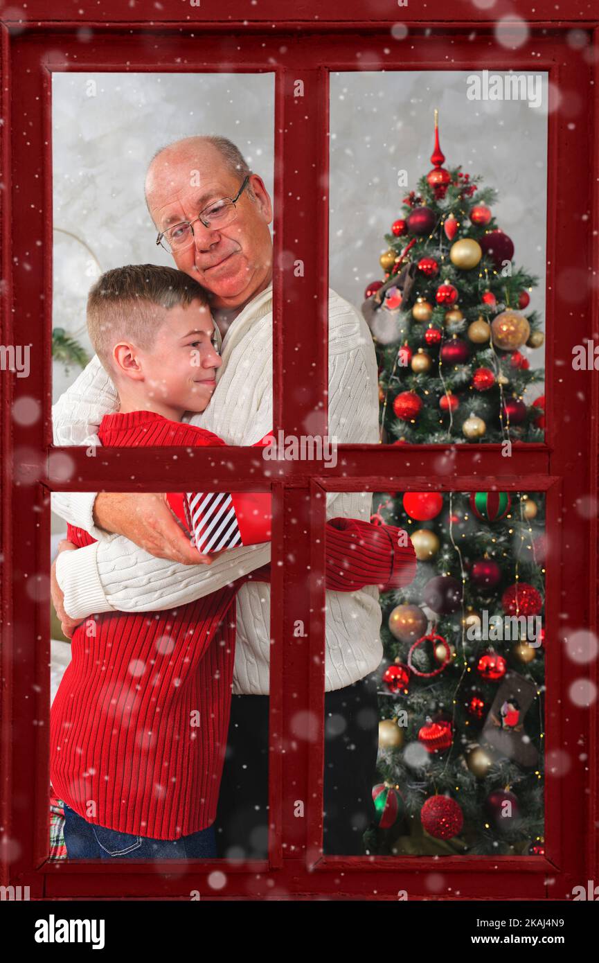 Christmas through the window. Christmas wonder. Grandson giving grandpa ...