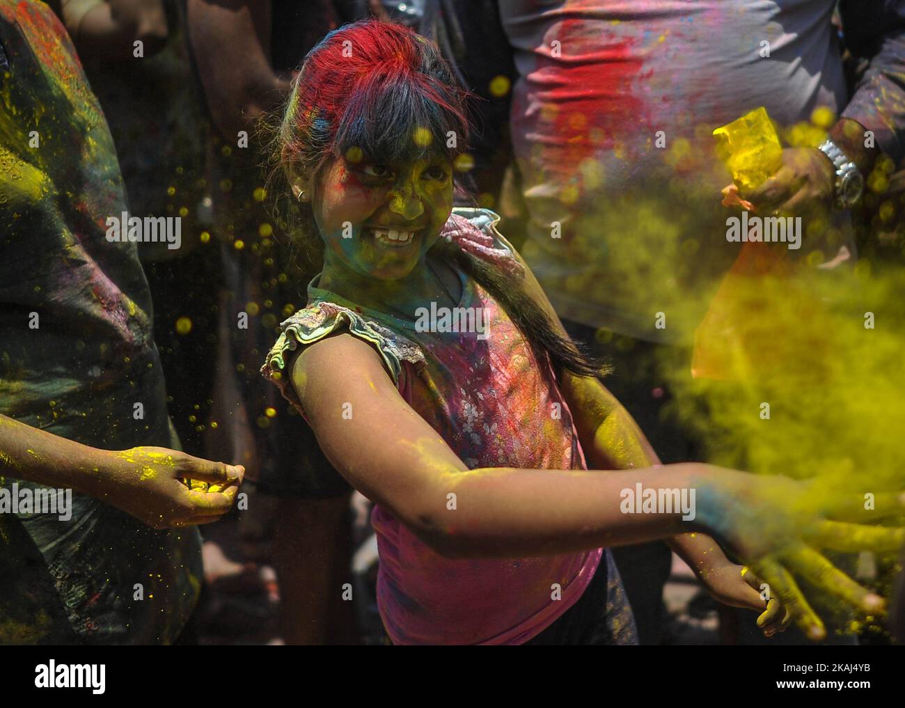 A girls throw coloured powder during Holi, the Hindu festival of colors ...