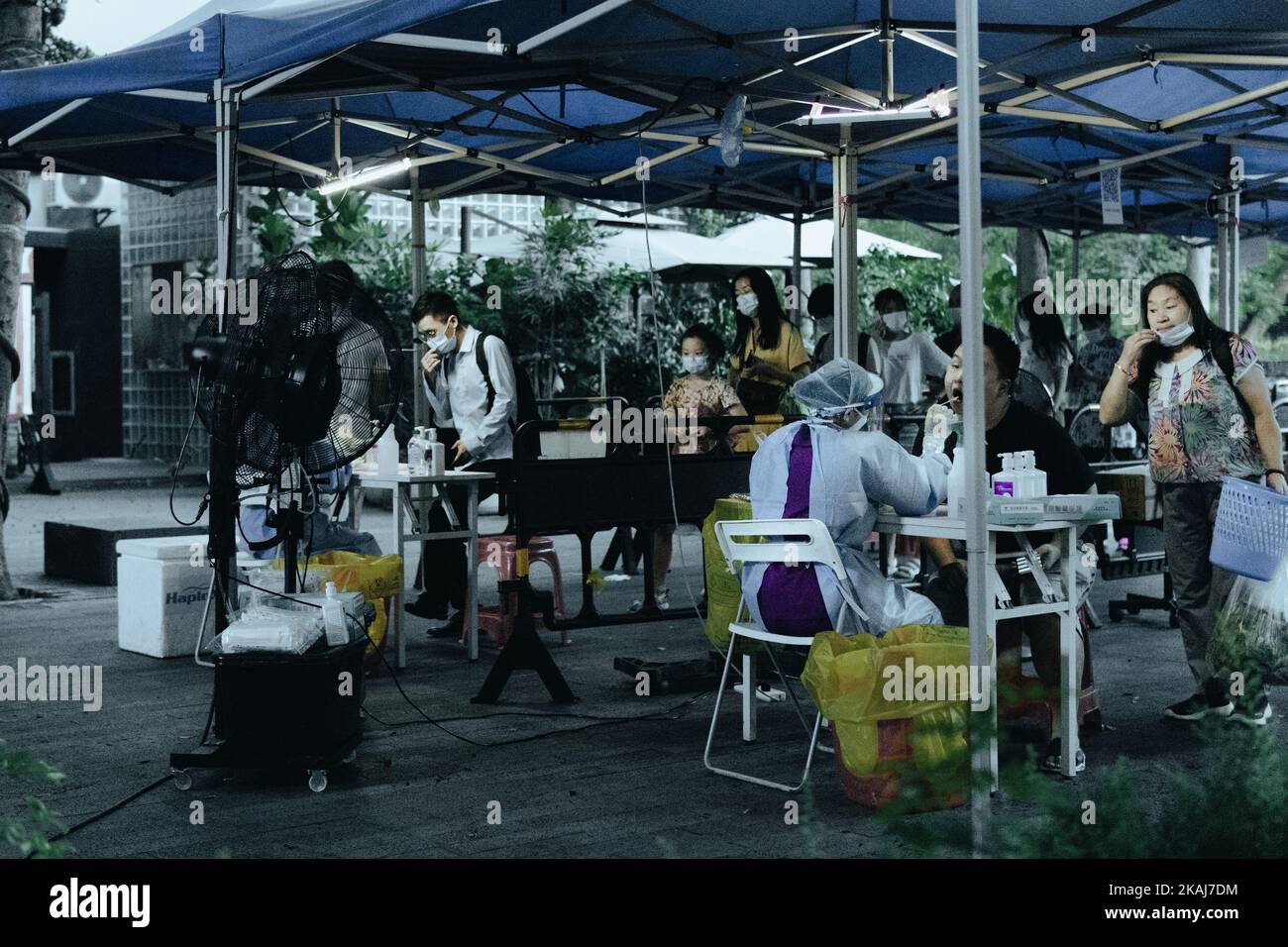 A group of Chinese people with masks queuing up for a nucleic acid PCR ...