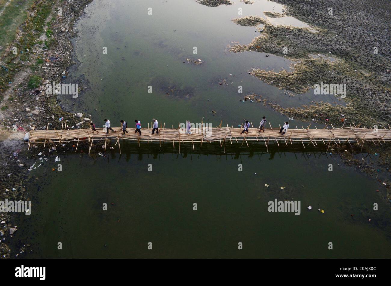 Indian commuters cross the partially dried Ganges River on a temporary ...