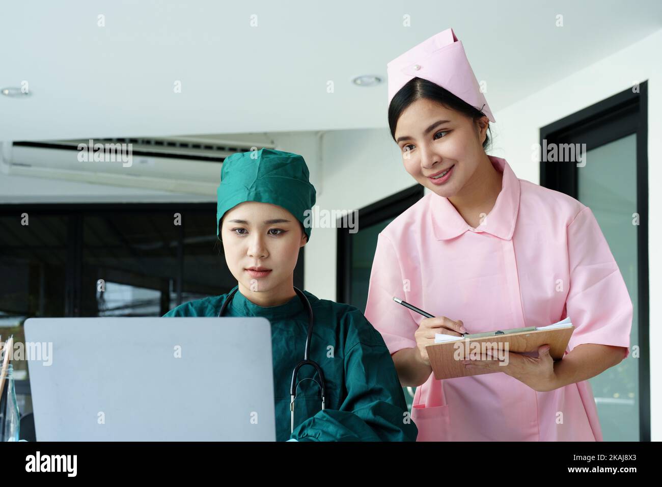 Asian Doctors And Nurses Using Computers And Documents To View Patient
