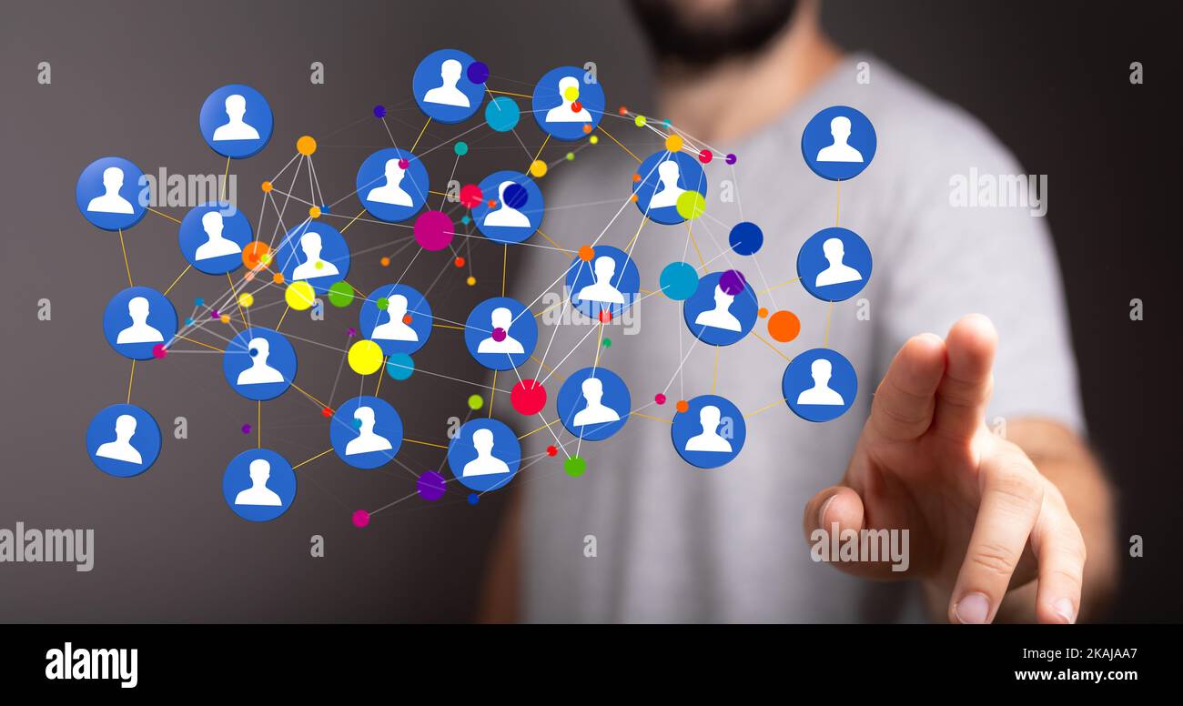 A blurred shot of a man pointing at illustrated digital icons of people ...