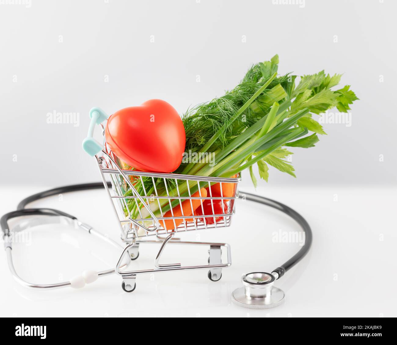 Health care still life with organic vegetables in a shopping cart with ...