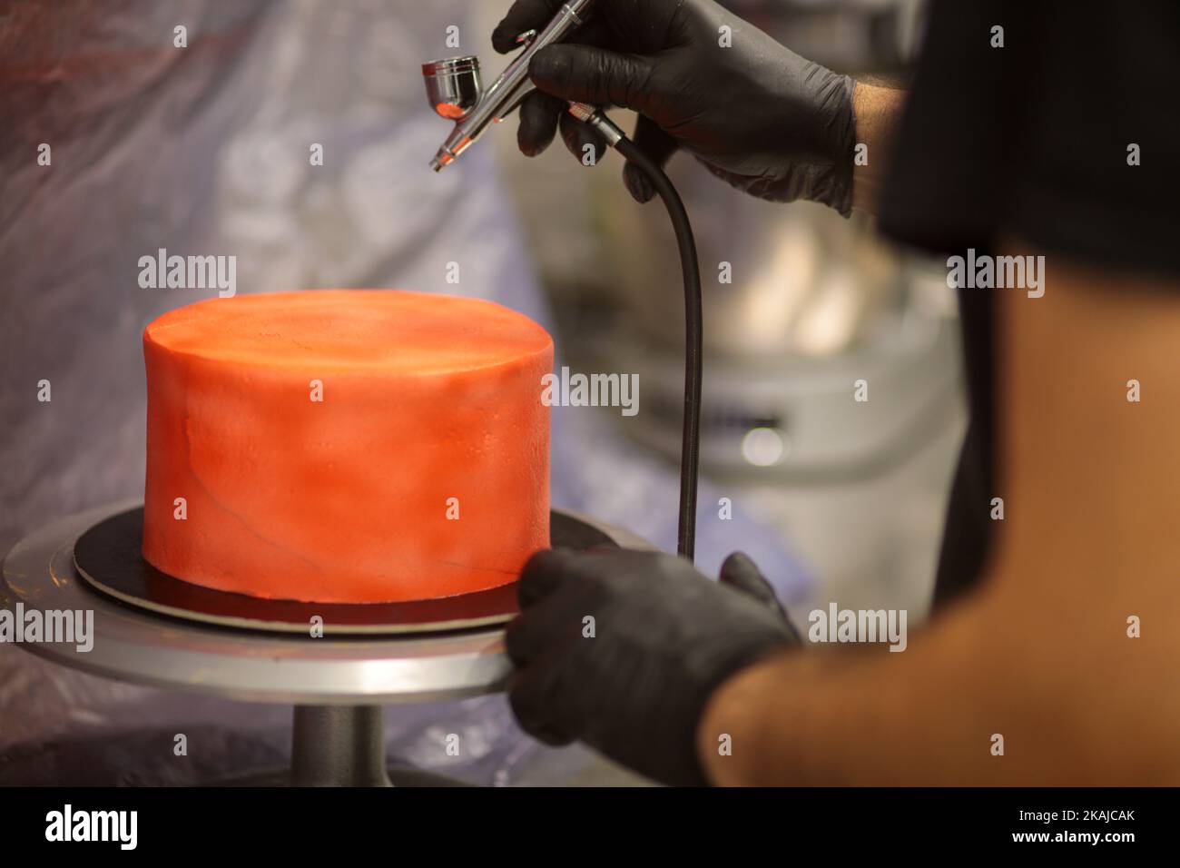 cook preparing a red frosted cake using air bush Stock Photo - Alamy