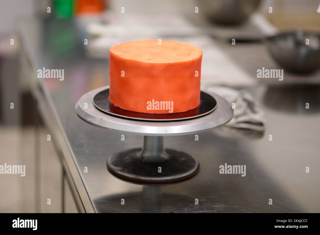 cook preparing a red frosted cake using air bush Stock Photo - Alamy