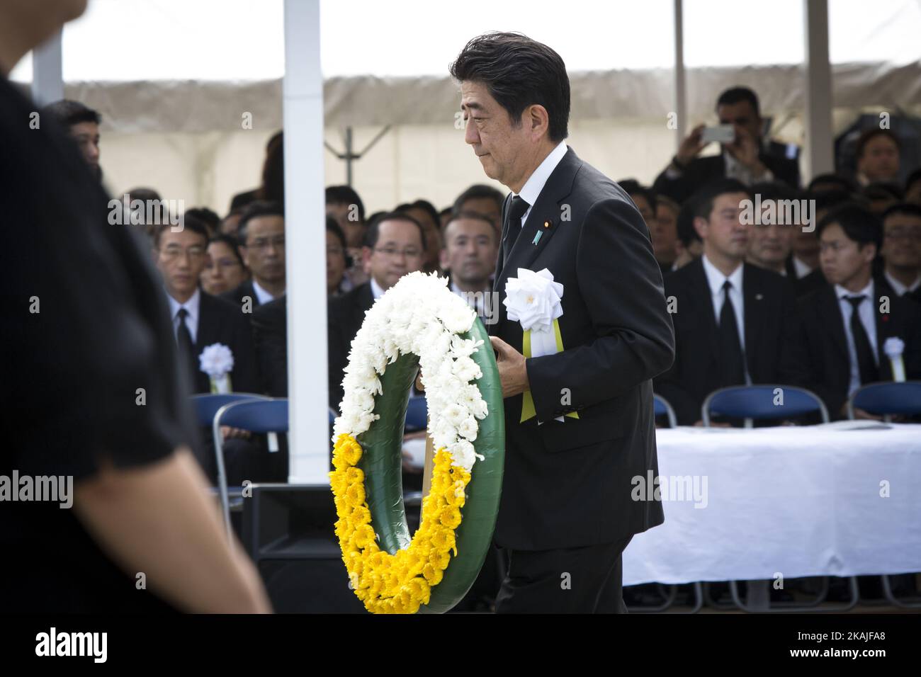 Japanese Prime Minister Shinzo Abe walks with the wreath to offer for ...