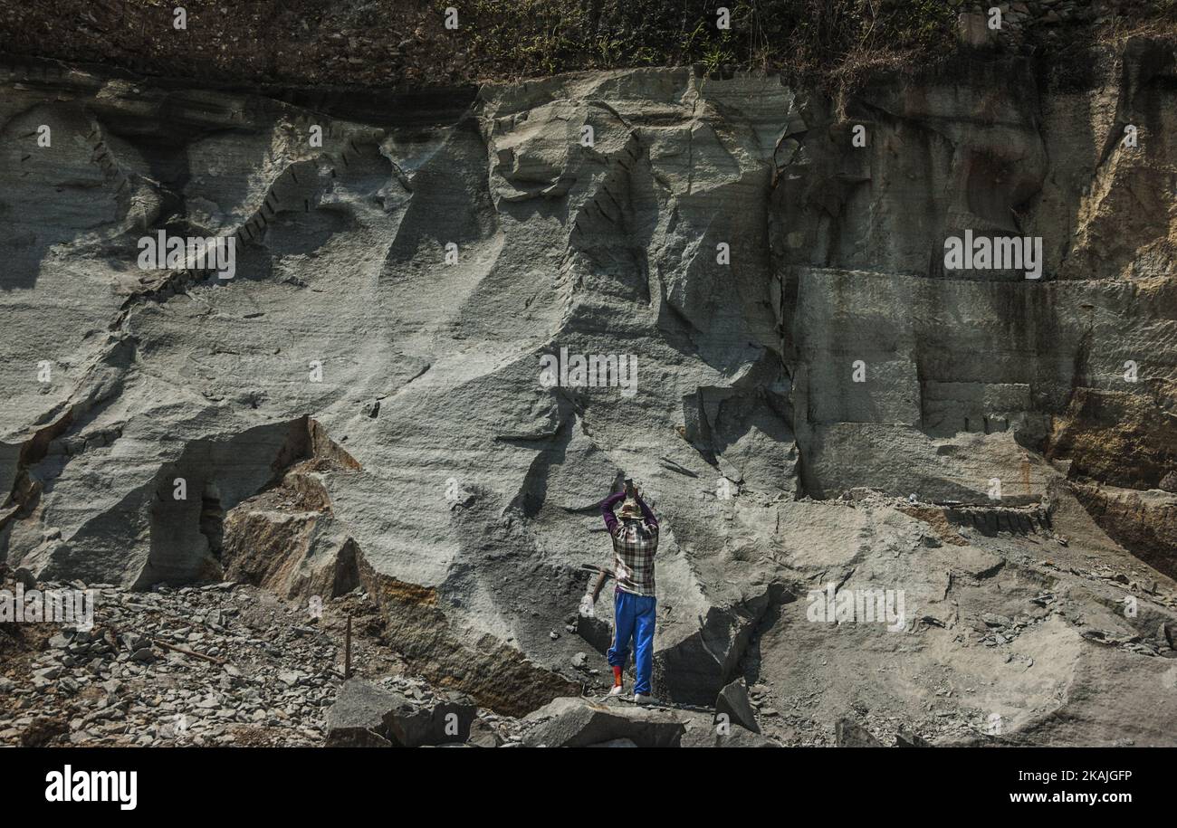 A man breaking stone breccia in Sambirejo, Yogyakarta, Indonesia, on ...