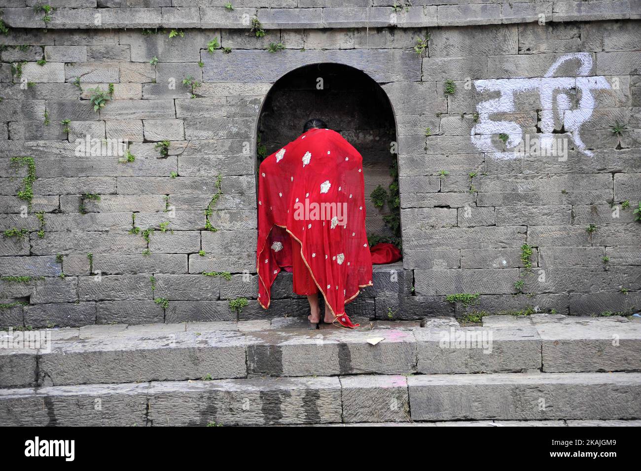 A Nepalese Hindu woman prepare for a ritual bath at the Bagmati River ...