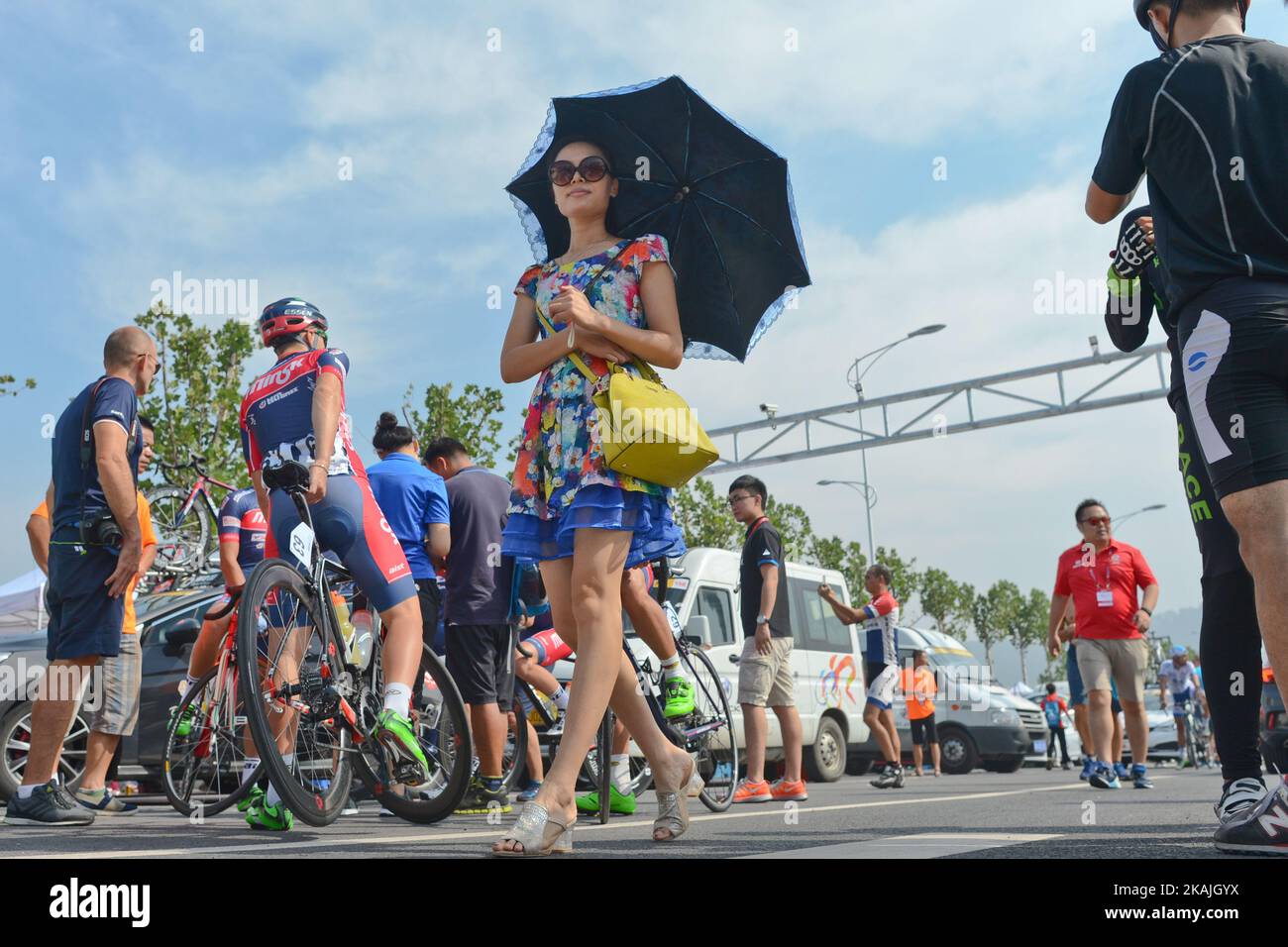 A local lady observes the riders preparation ahead of the 114.7 km ...