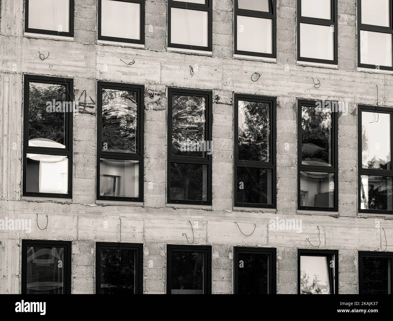A monochrome closeup shot of a stone building with lots of windows ...
