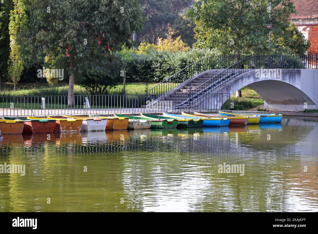 The view of colorful docked boats by the bridge over a lake in Jardim ...
