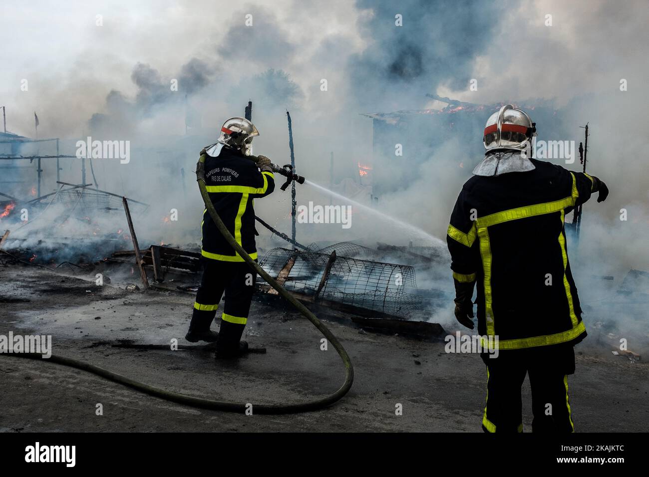 Firefighter extinguish in the Calais Jungle a burning hut, on October ...