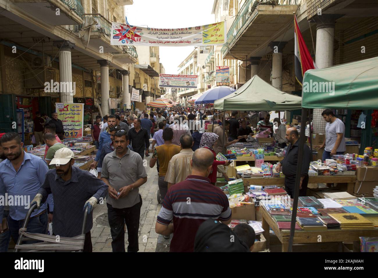Iraqis look at books displayed outside bookshops on al-Mutanabi street ...