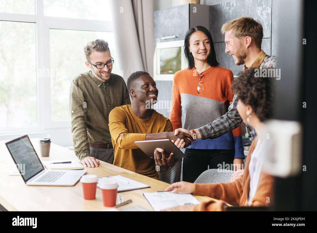 happy employees shaking hands at work in a coworking center Stock Photo ...