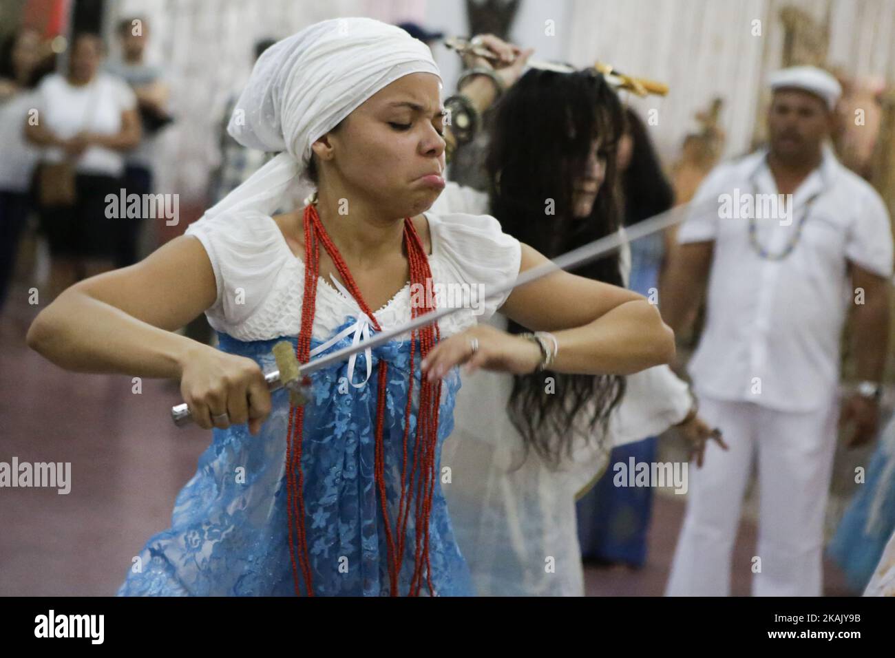 A woman, taken by a spirit, dances in trance with a plastic sword ...