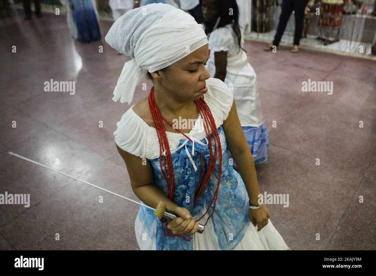 A woman, taken by a spirit, dances in trance with a plastic sword ...