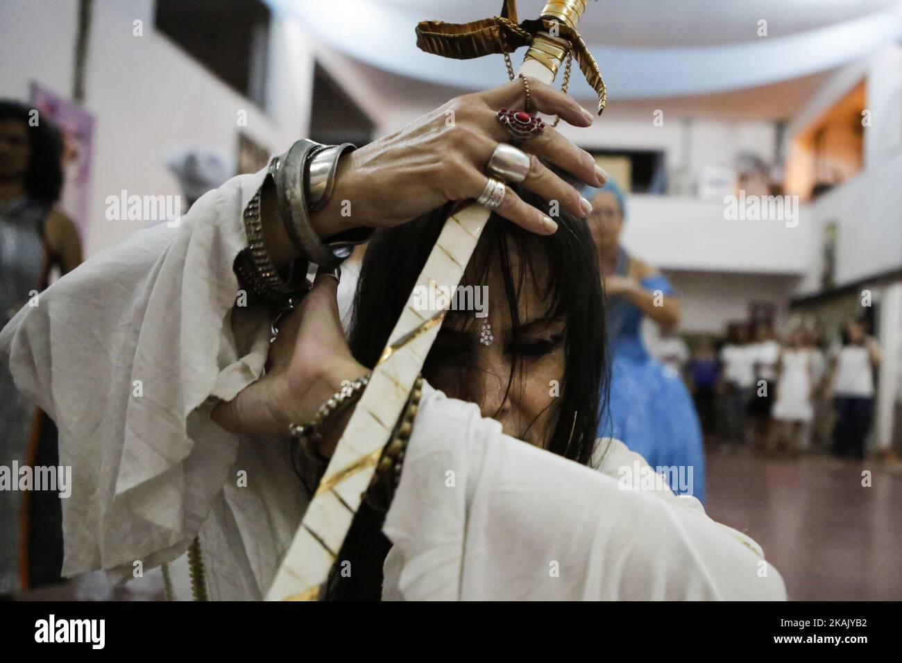 A woman, taken by a spirit, dances in trance with a metal sword during ...