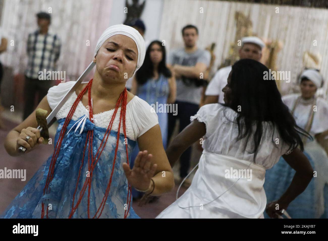 A woman, taken by a spirit, dances in trance with a plastic sword ...