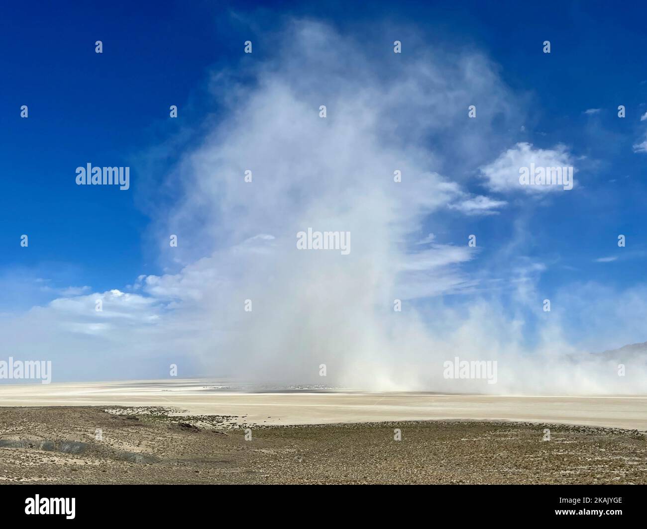 A long shot of a dust devil in a dry field, during the dry weather and ...