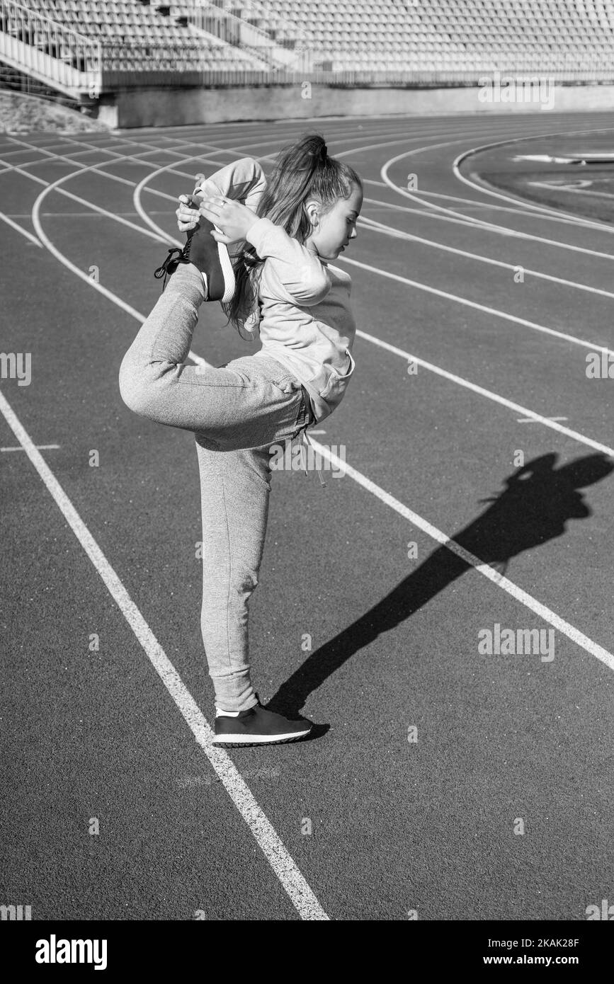 Stretching for better flexibility. Flexible child hold foot standing on ...