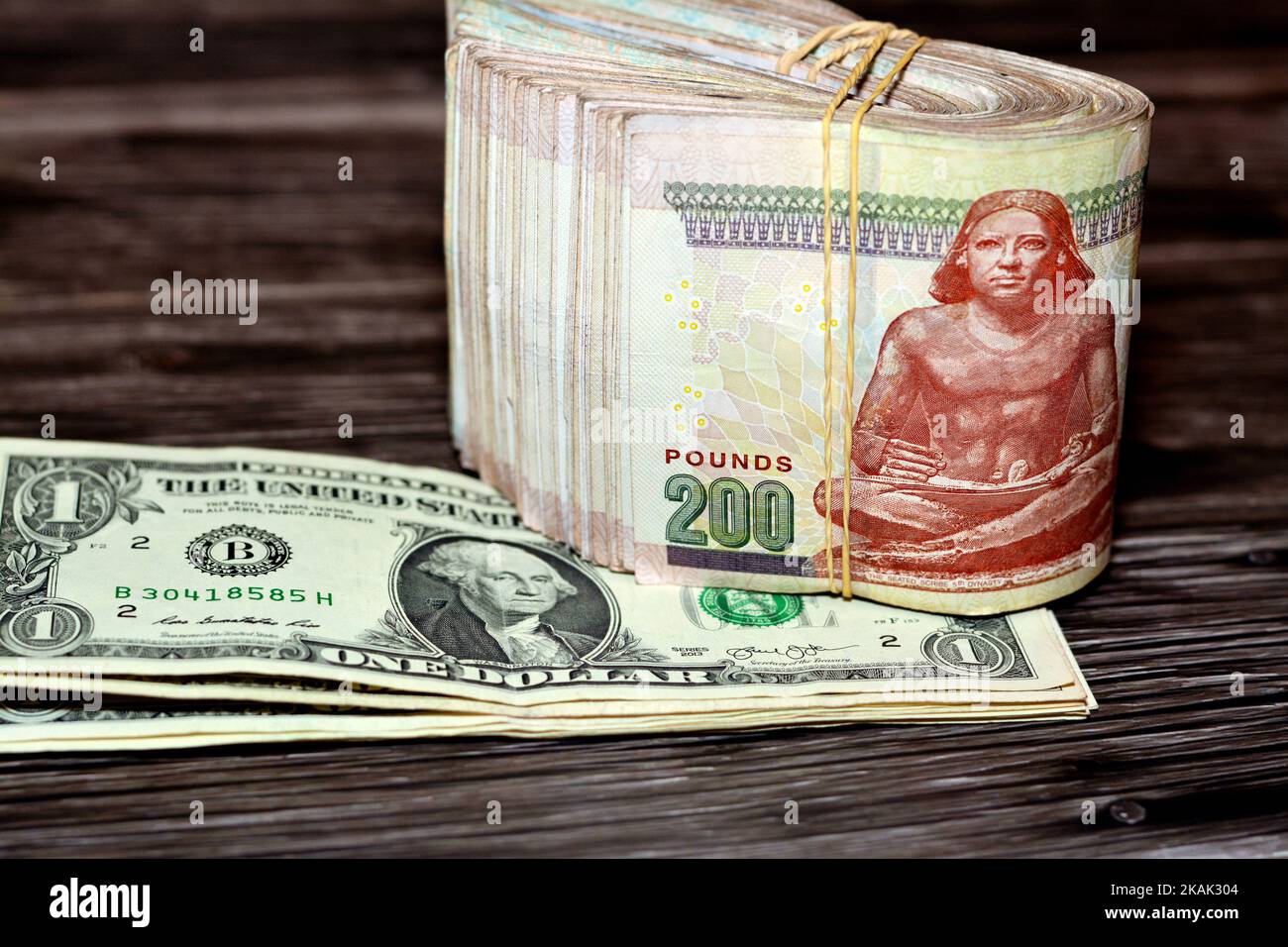 Folded Egyptian money 200 LE and pile of American money isolated on ...