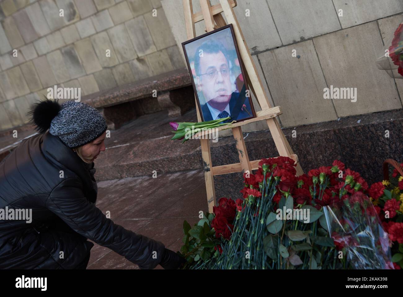 A woman brings flowers to a portrait of Russian Ambassador to Turkey ...