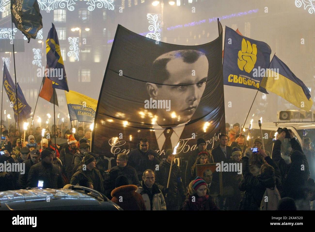 Ukrainian nationalists carry torches and banner with Bandera and ...
