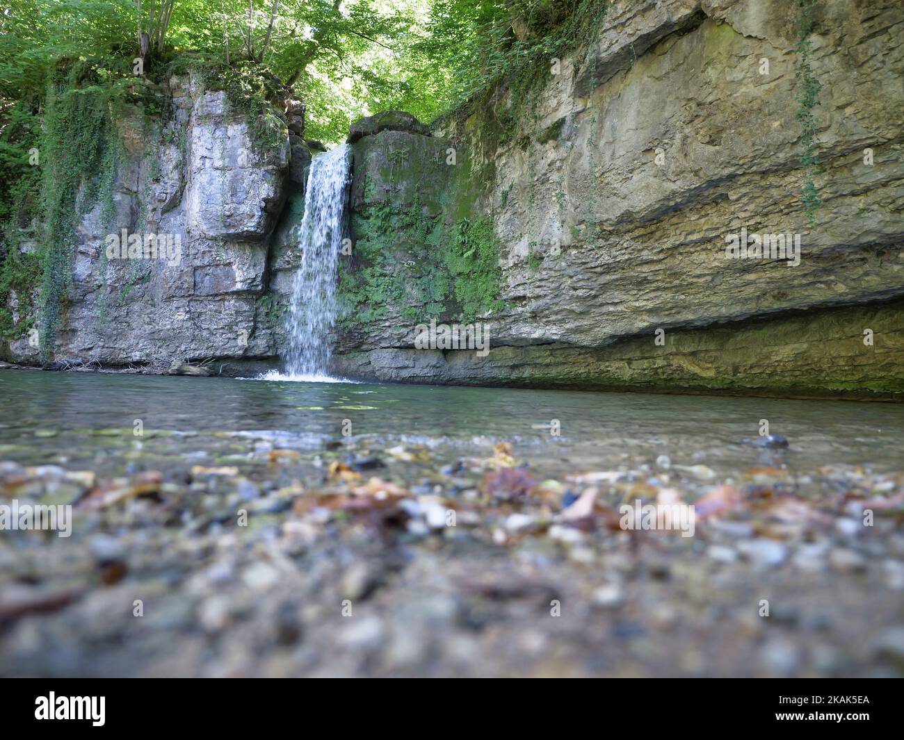 A waterfall flowing over the rock formation to the ground Stock Photo ...