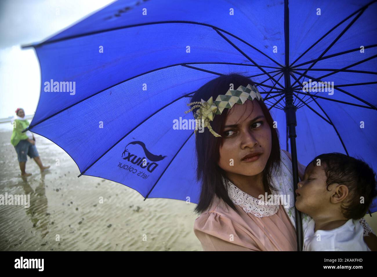 Women of the Mah Meri tribe look their members performs prayers on the ...