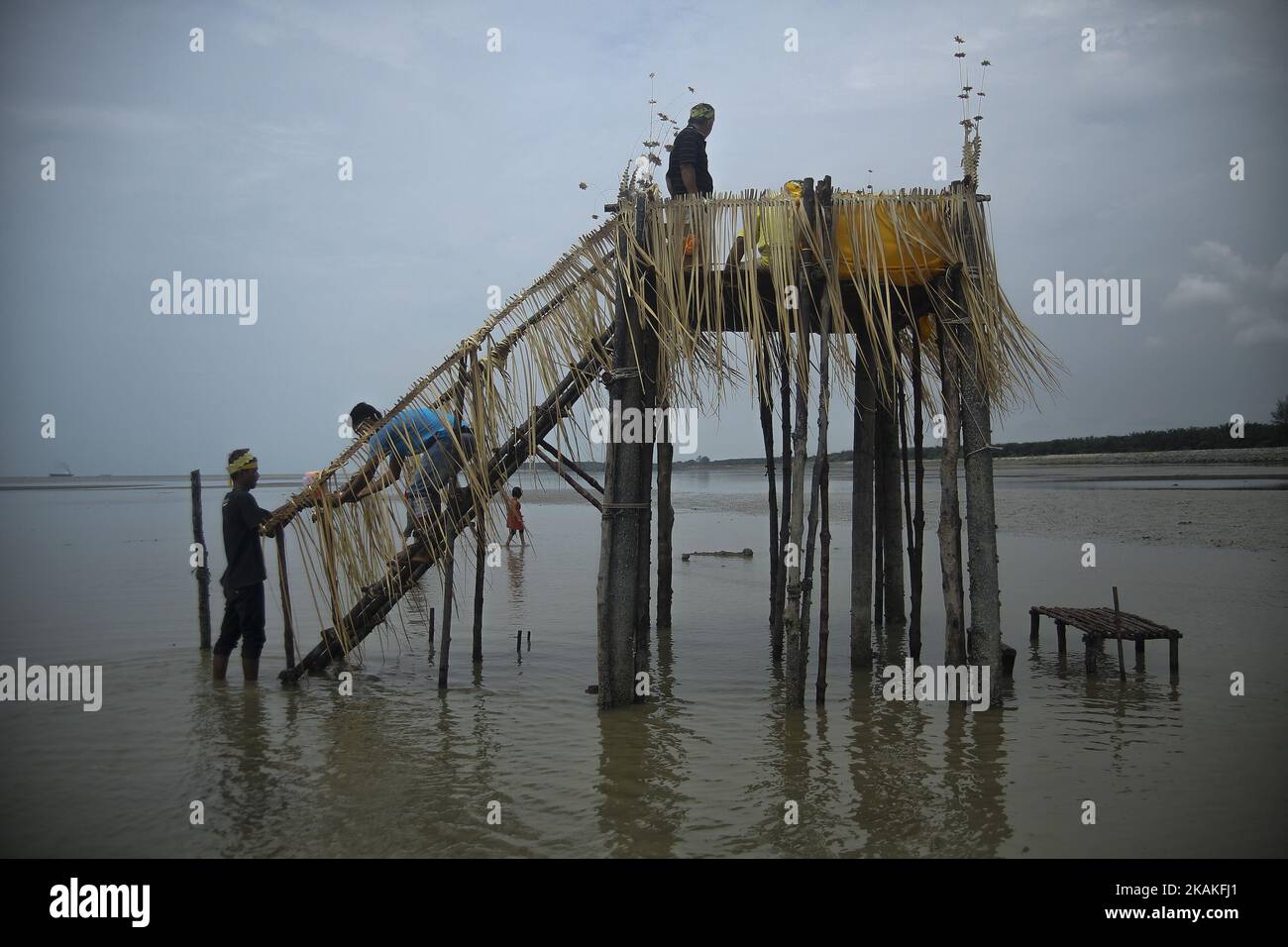 Members of the Mah Meri tribe make a final prerations on the beach as ...
