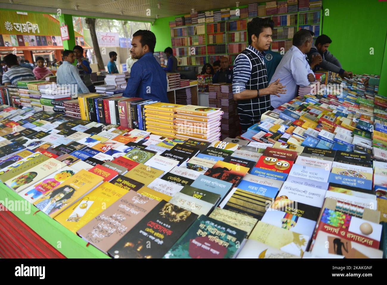 Bangladeshi shoppers brows books at a stall during the country's largest book fair in Dhaka on ...