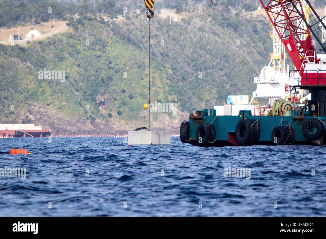 Concrete blocks is seen from barges before dropping into the sea during ...