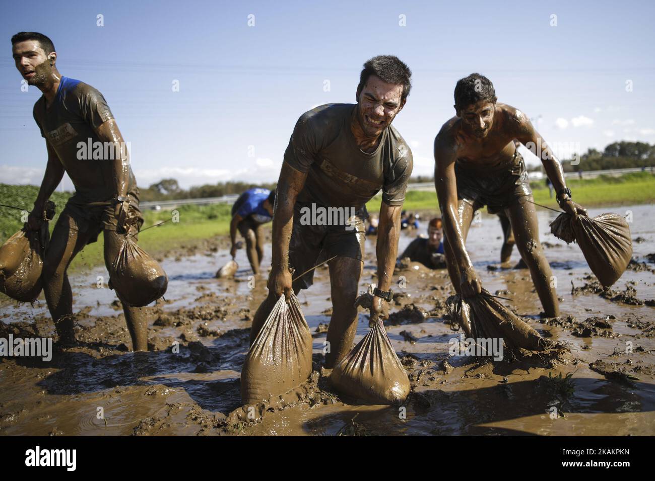 Israeli teenagers walk with heavy sandbags through mud as they take ...