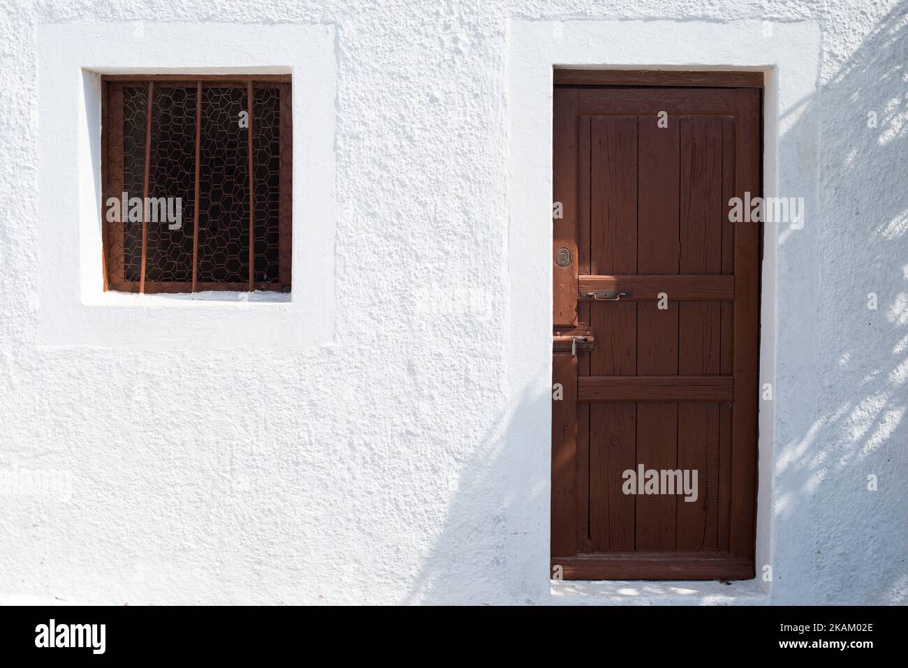 A small, simple building on the island of Santorini with one door and ...