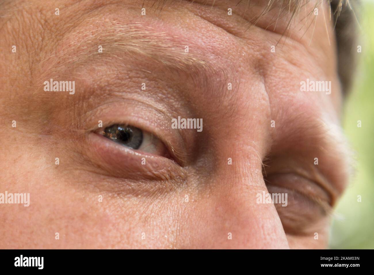 The blond man narrowed his eyes. Close-up Stock Photo - Alamy