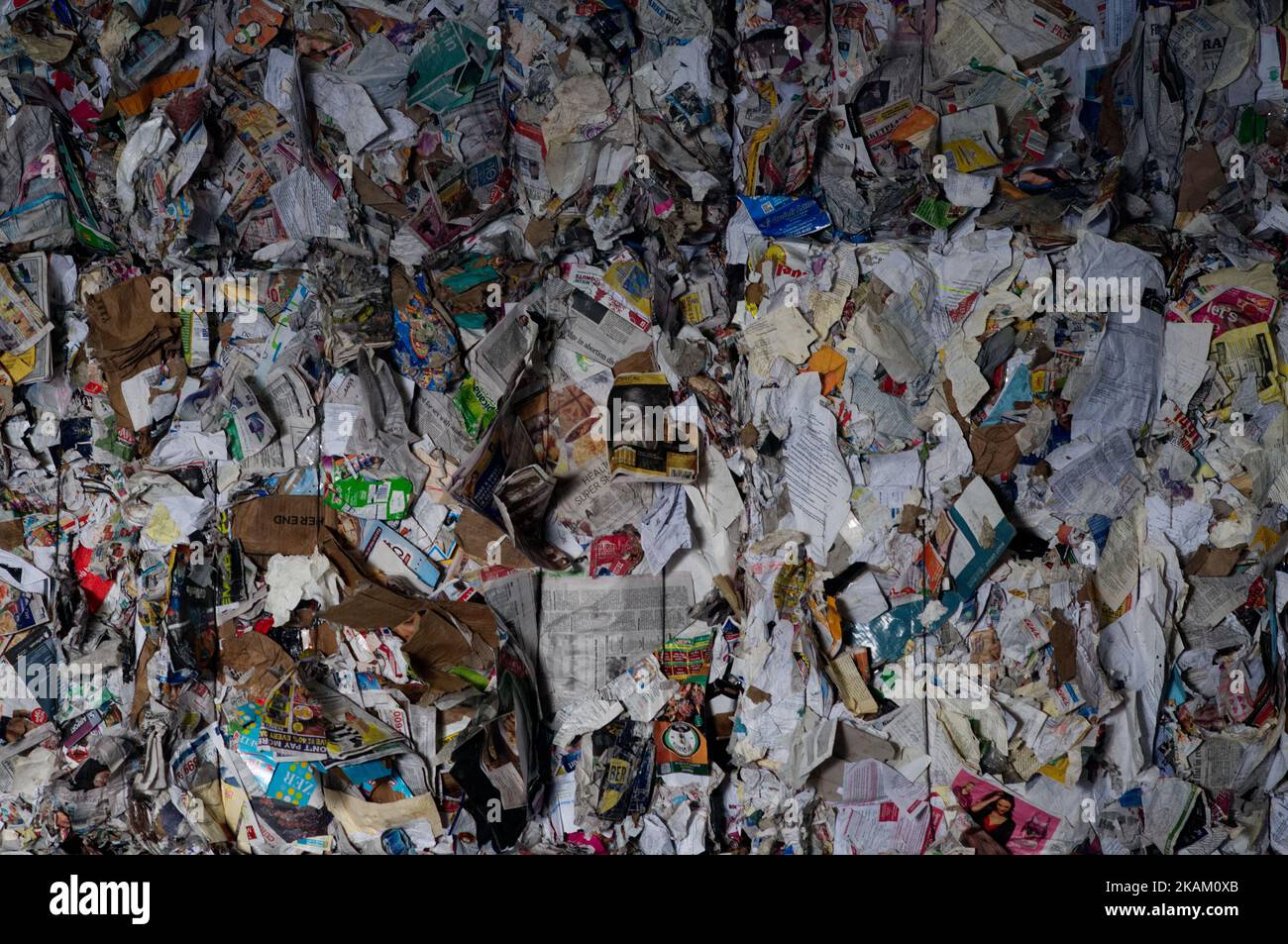 Bales of cardboard, paper and plastics are stacked up high at the end ...