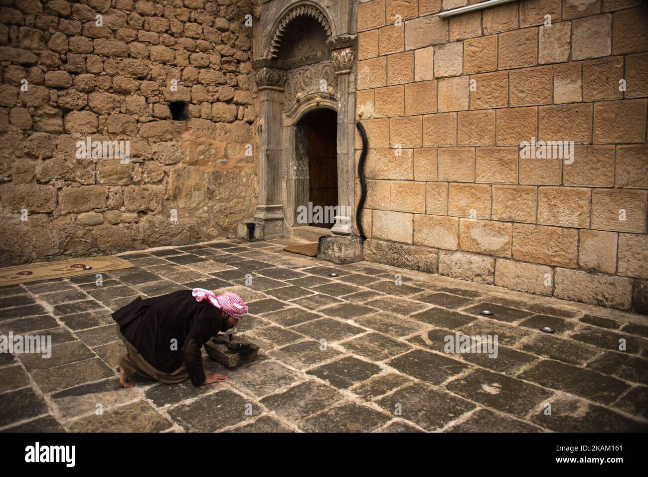 A Yazidi man performs a religious ritual at the holiest temple of the ...