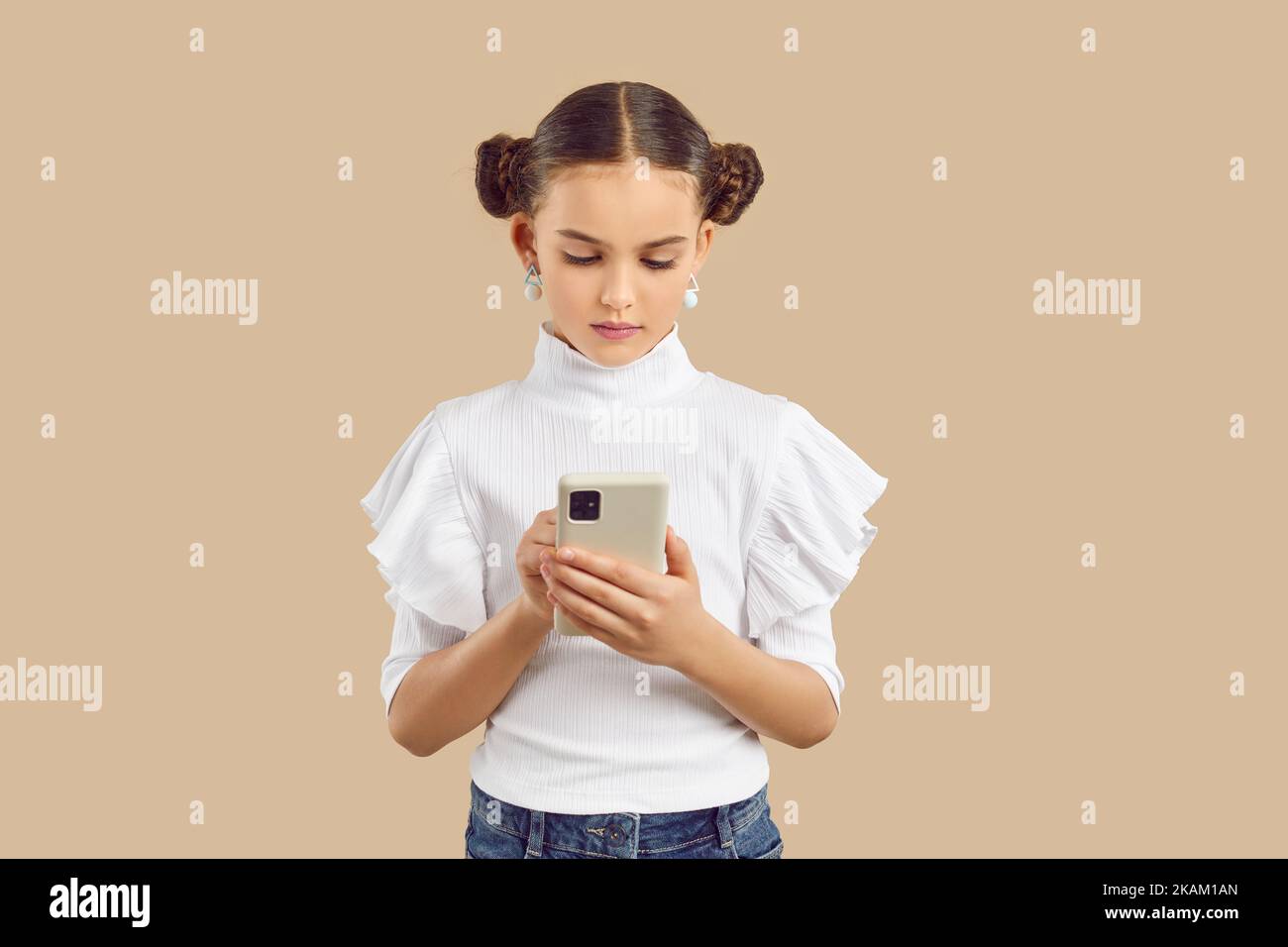 Pretty little child holding smartphone, texting messaging and using ...