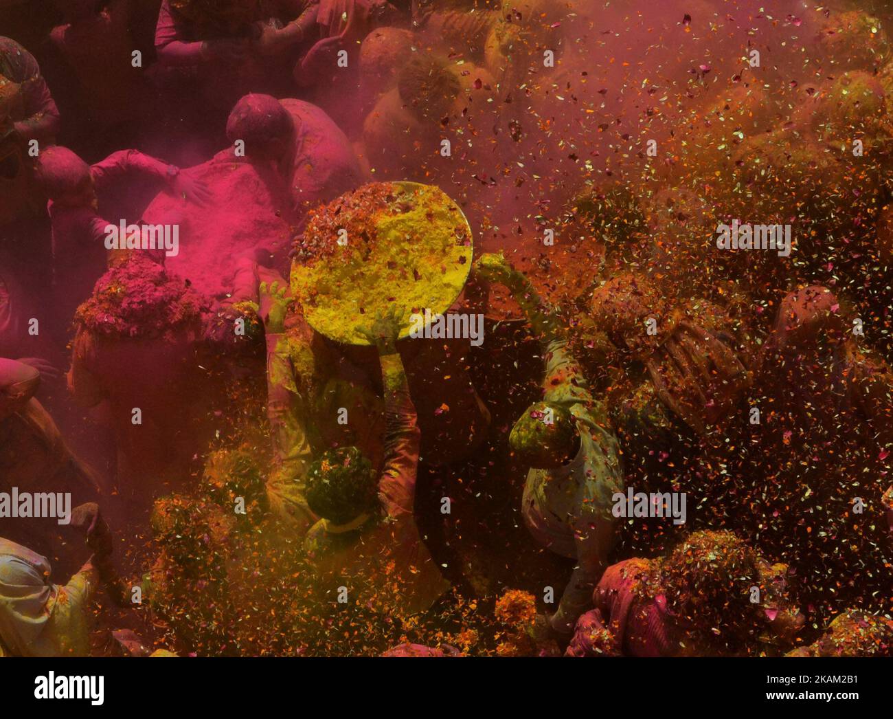 Indian Widows covered with colored powder and flower petels dance as ...