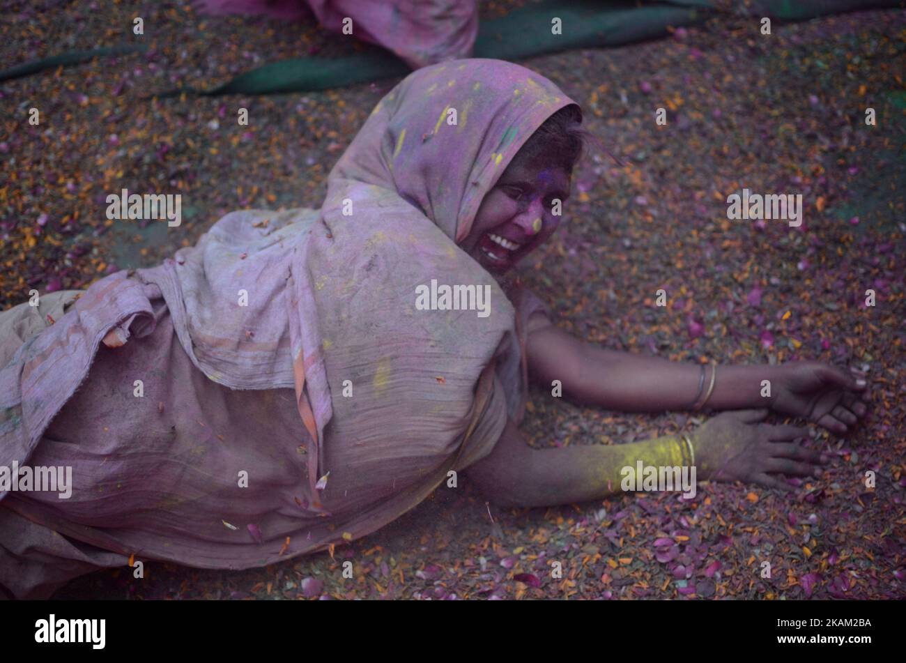 An indian Widow covered with colored powder and flower petels dance as ...