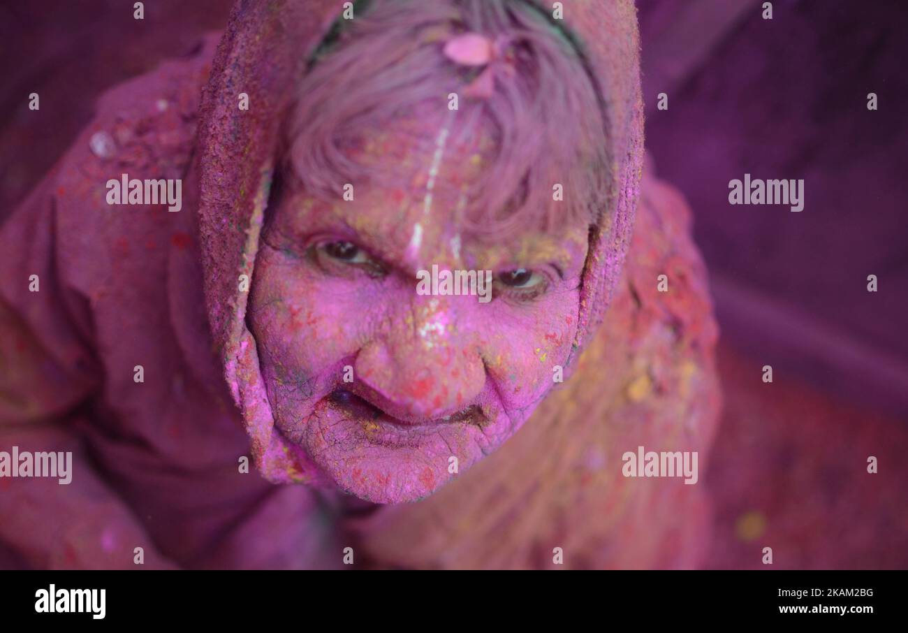 An indian Widow covered with colored powder and flower petels dance as ...