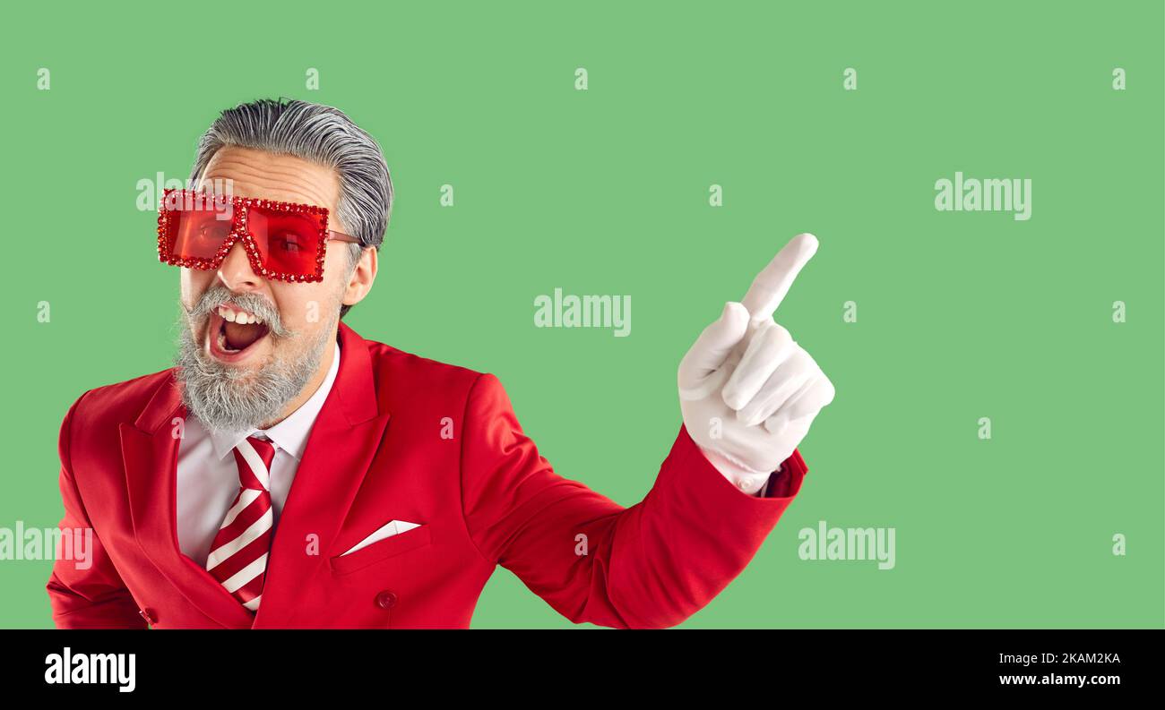 Happy bearded man in red suit and funny glasses advertising Christmas ...